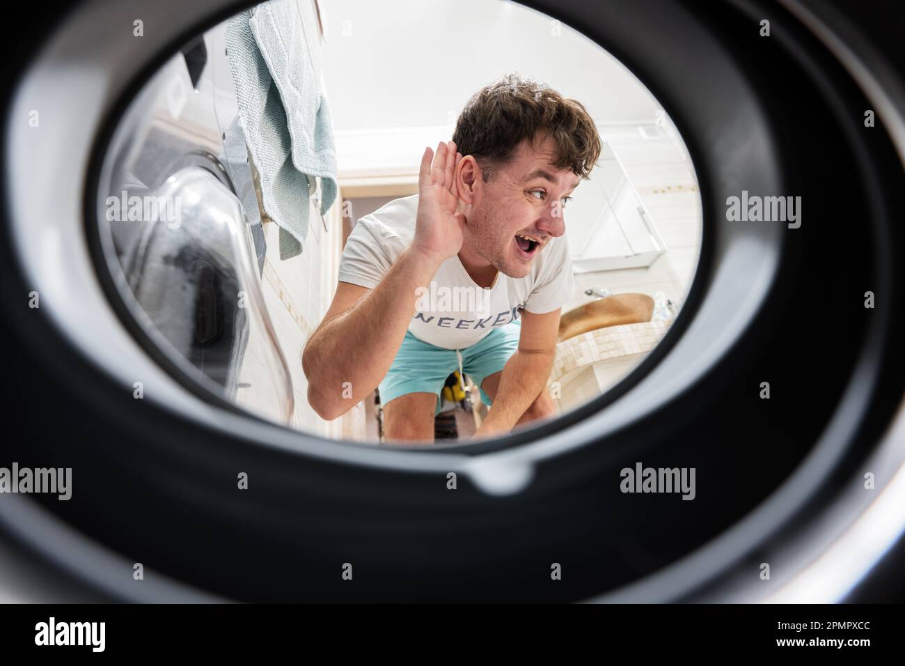 Man view from washing machine inside. Male does laundry daily routine ...