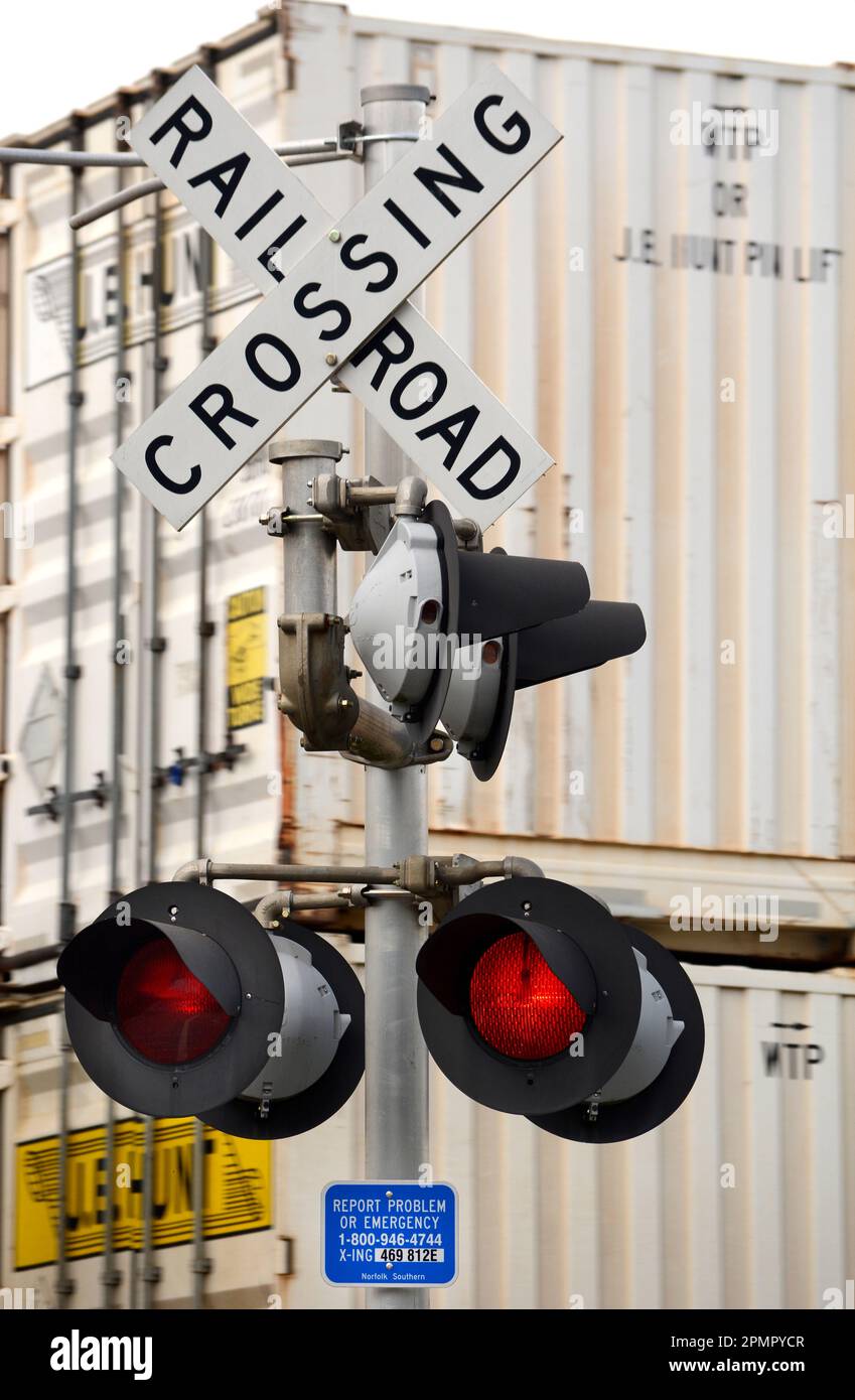 A railroad crossing signal flashes lights as a Norfolk SouthernRailways ...