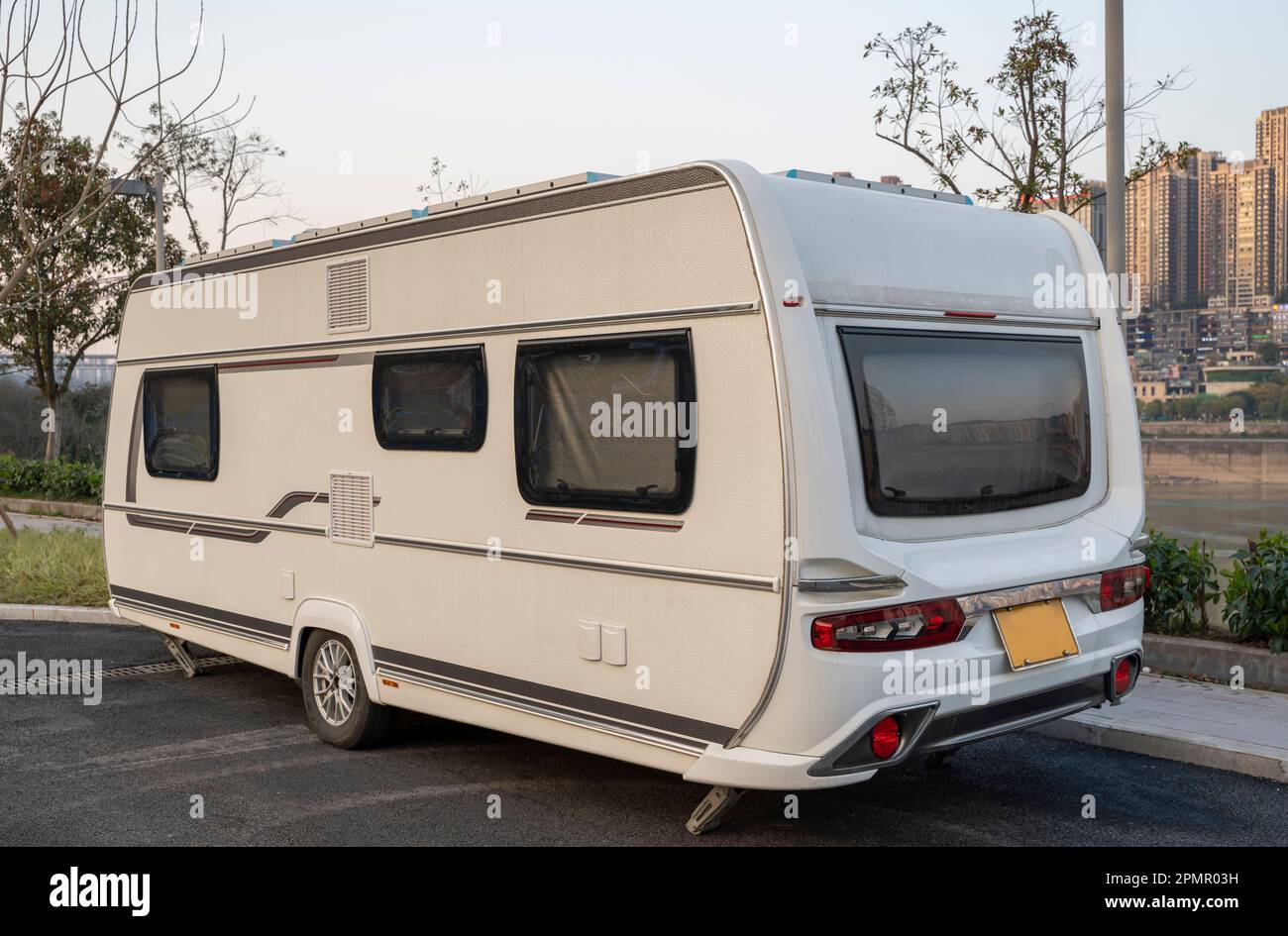 A modern white caravan vehicle parked outdoors in the daylight Stock ...