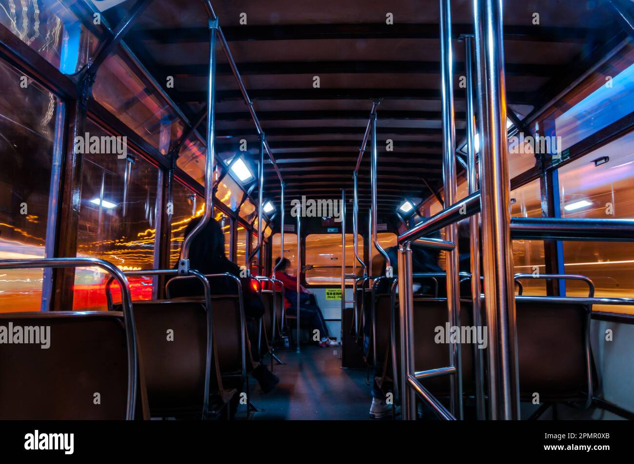 A public transportation bus illuminated in the night, full of ...