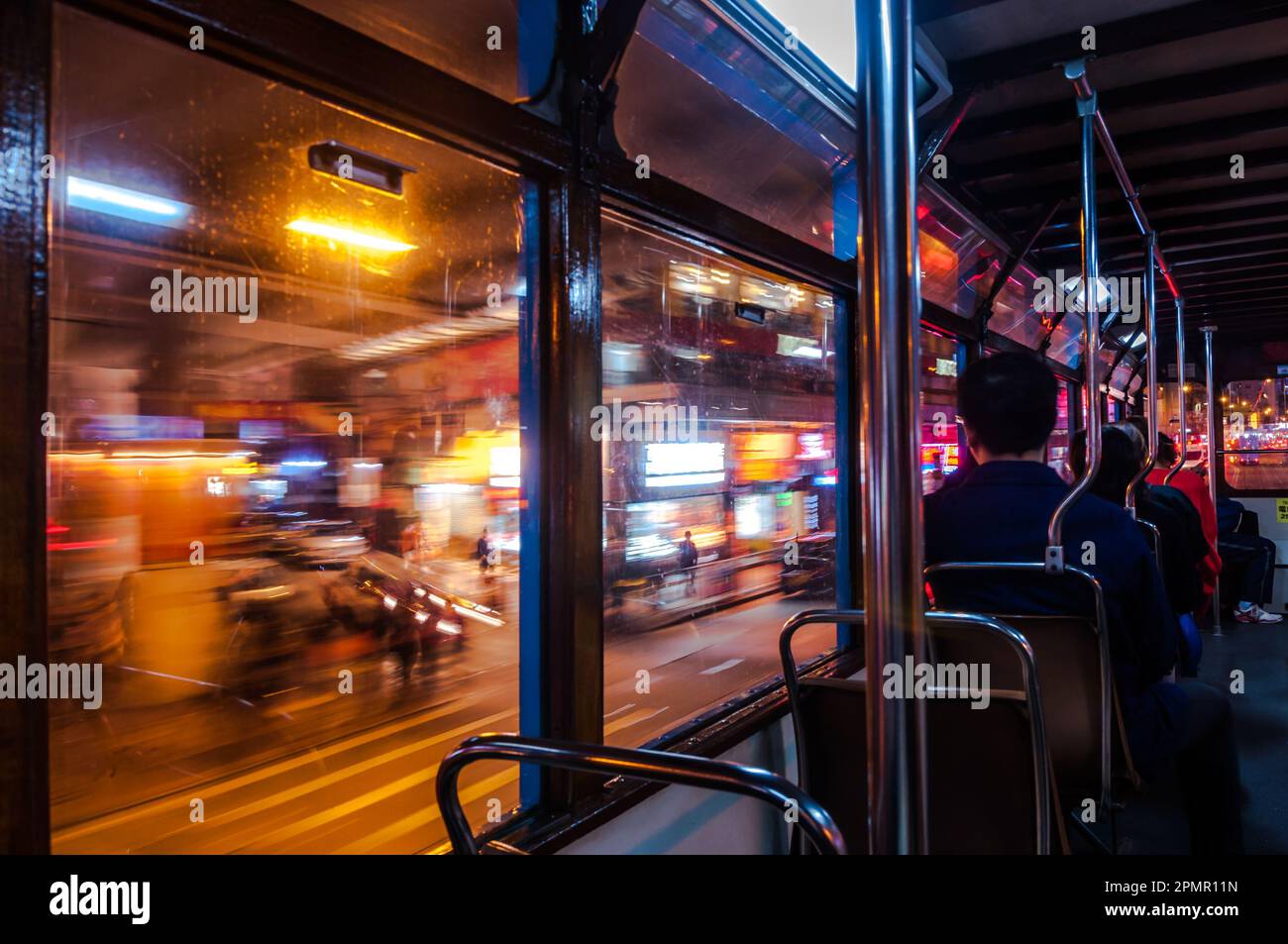A public transportation bus illuminated in the night, full of ...