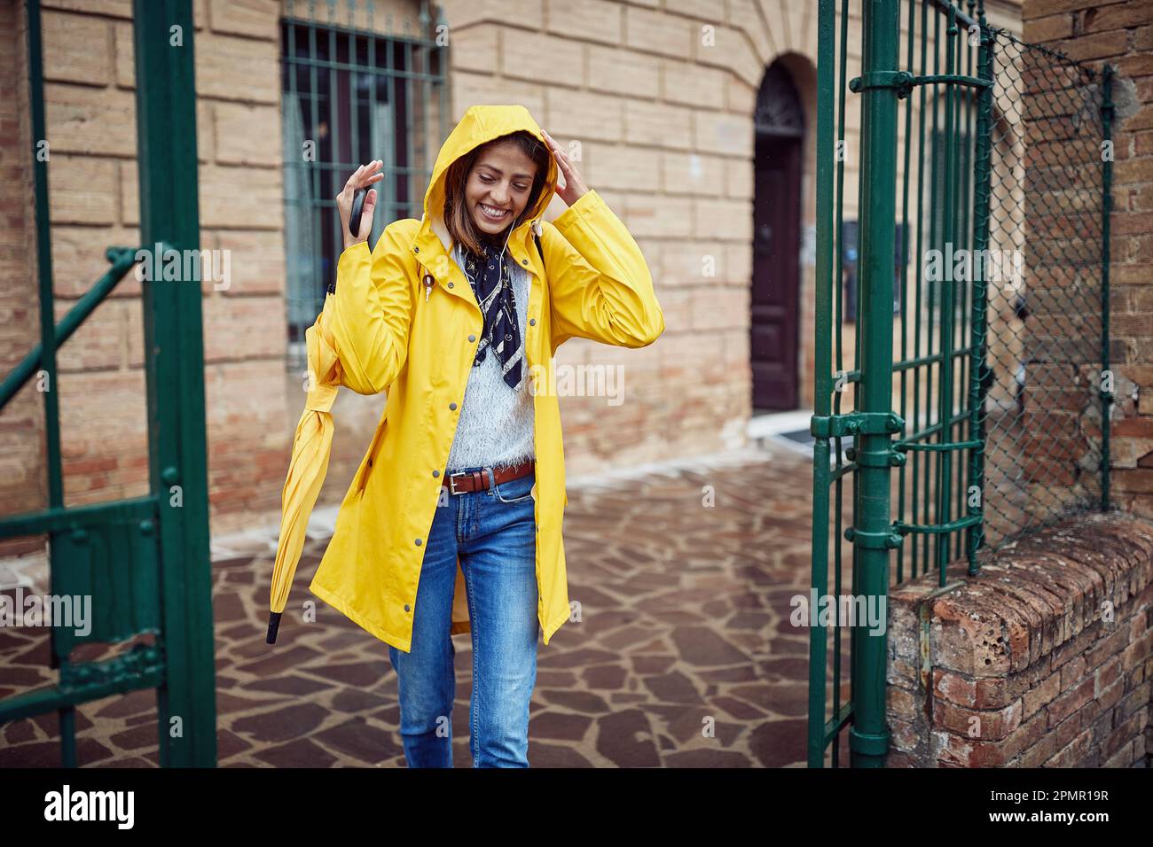 A Young Girl In Yellow Raincoat Walking Through The City On The Rain In A Good Mood Walk Rain