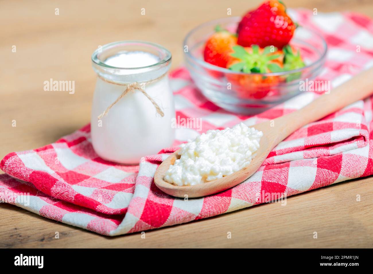 Kefir grains in wooden spoon in front of cups of Kefir Yogurt Parfaits ...