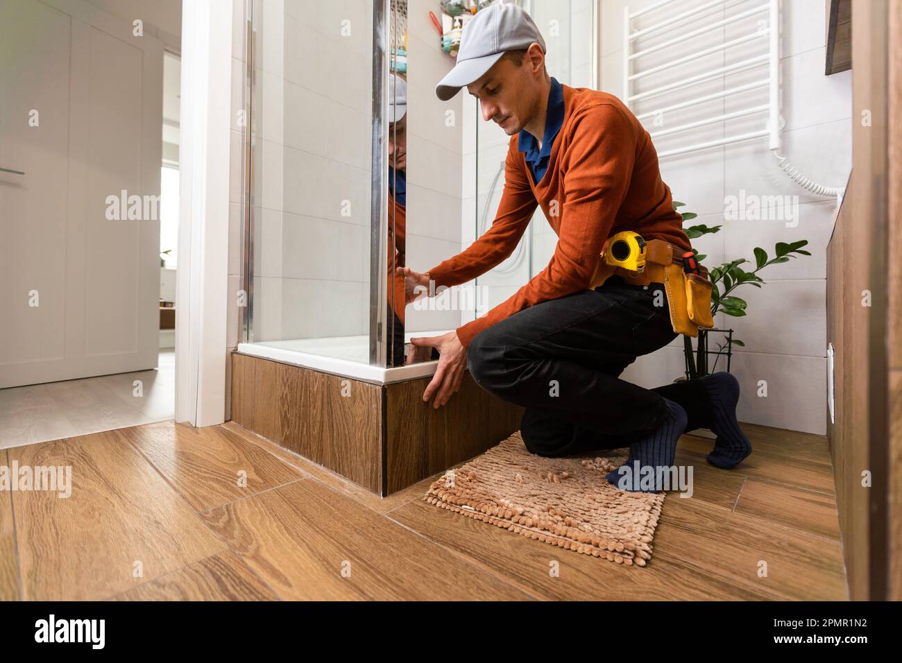 Plumber installing a shower cabin in bathroom Stock Photo - Alamy
