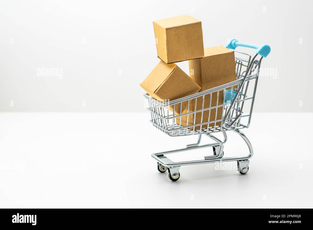 Top view of toy shopping cart with cardboard boxes on the white ...