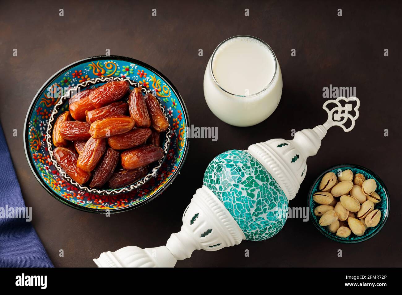 Ramadan Kareem food and drinks. Date fruits, nuts and milk on a dark ...