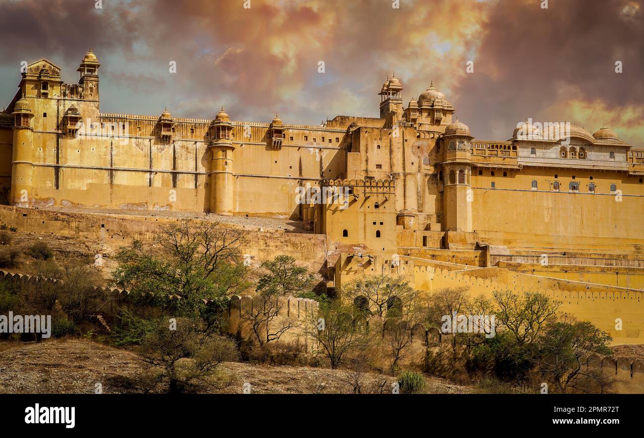 Amber Fort illuminated by warm light of the rising sun and reflected in ...
