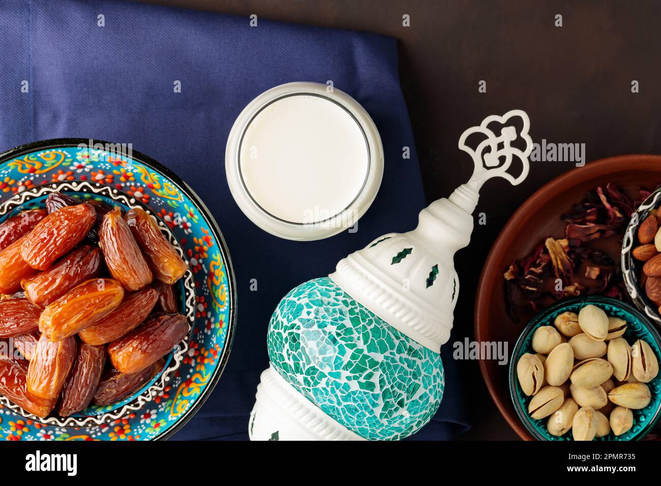 Ramadan Kareem food and drinks. Date fruits, nuts and milk on a dark ...