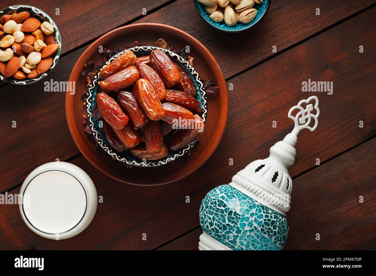 Ramadan Kareem and iftar muslim food. Pitted dates, nuts and milk on ...