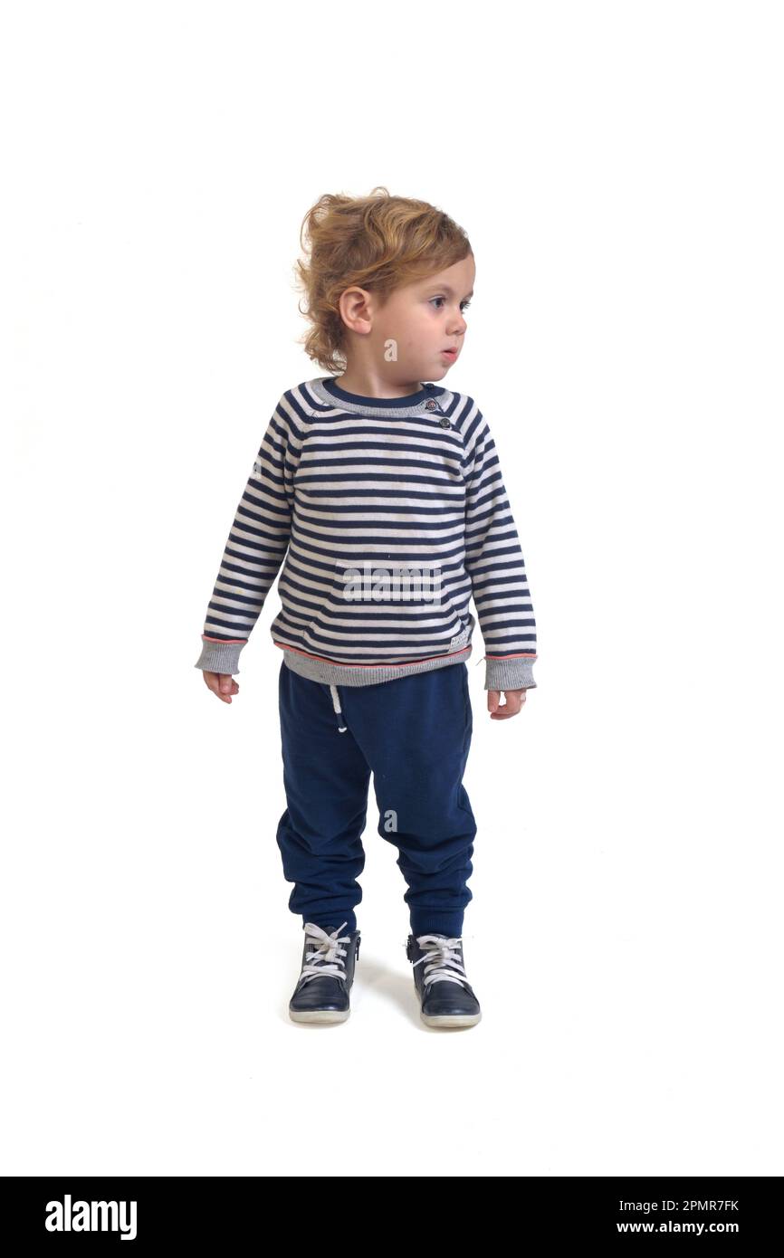 front viw of a baby boy standing and looking away on white background ...