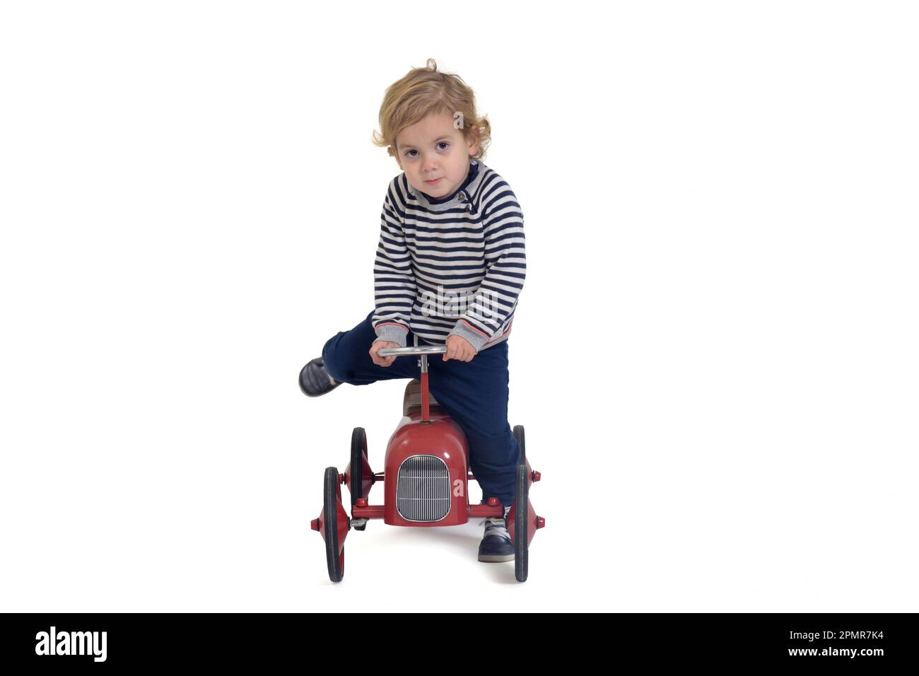 front view of a baby playing with a toy car going in and out of the car ...