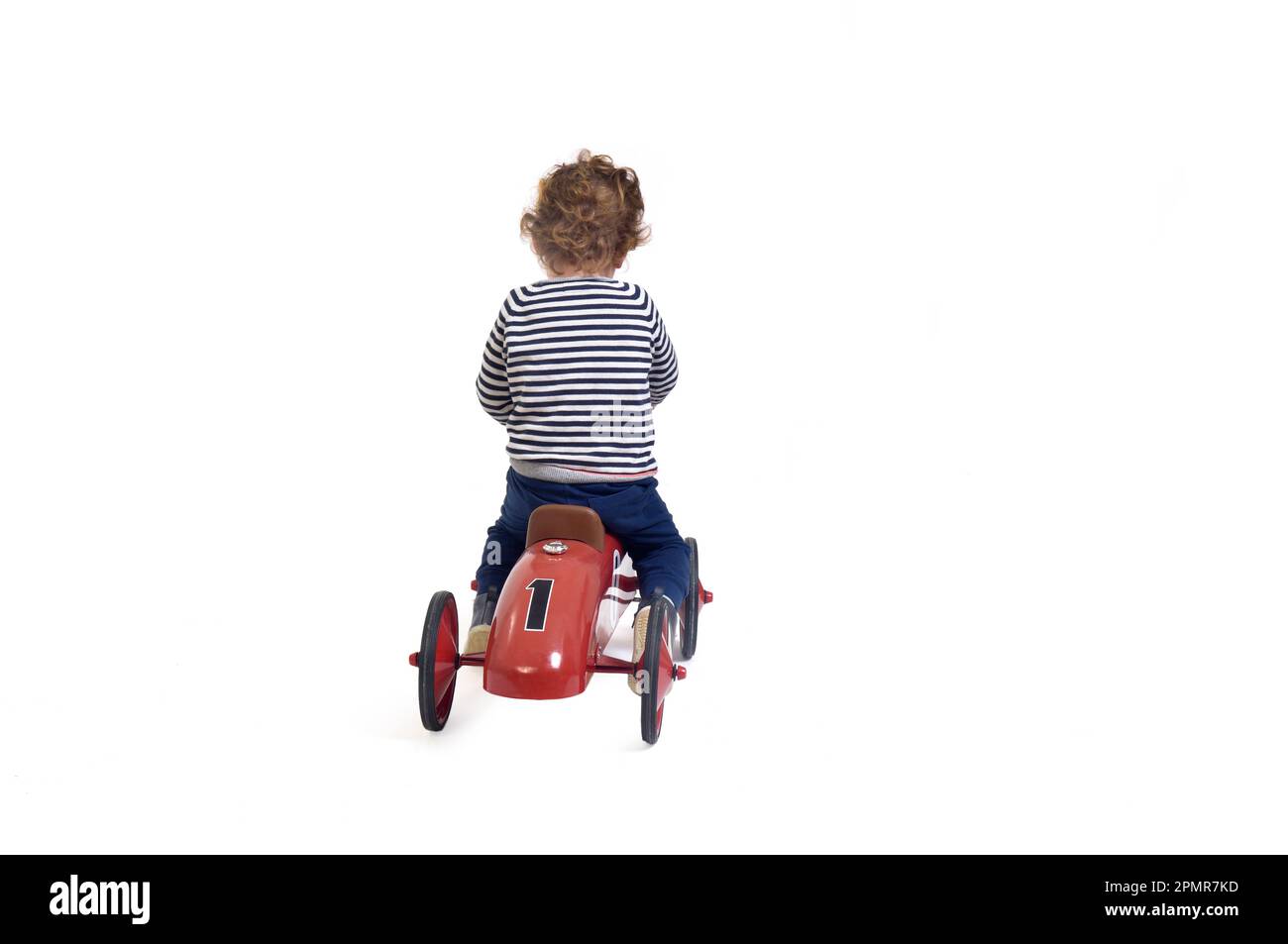 back view of a baby boy playing with car toy on white background Stock ...