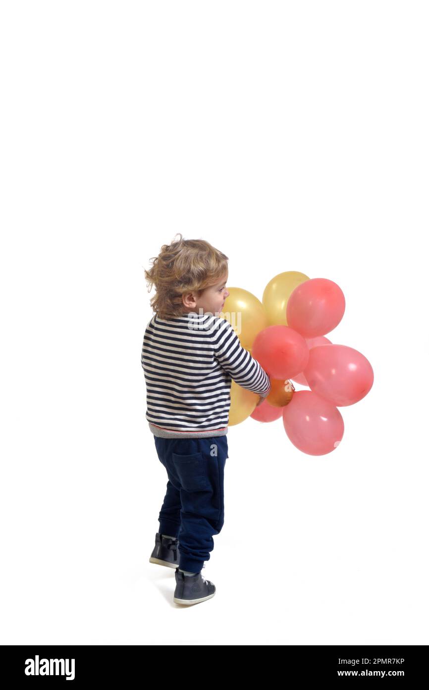 side back view of a baby playing with air balloon on white background ...
