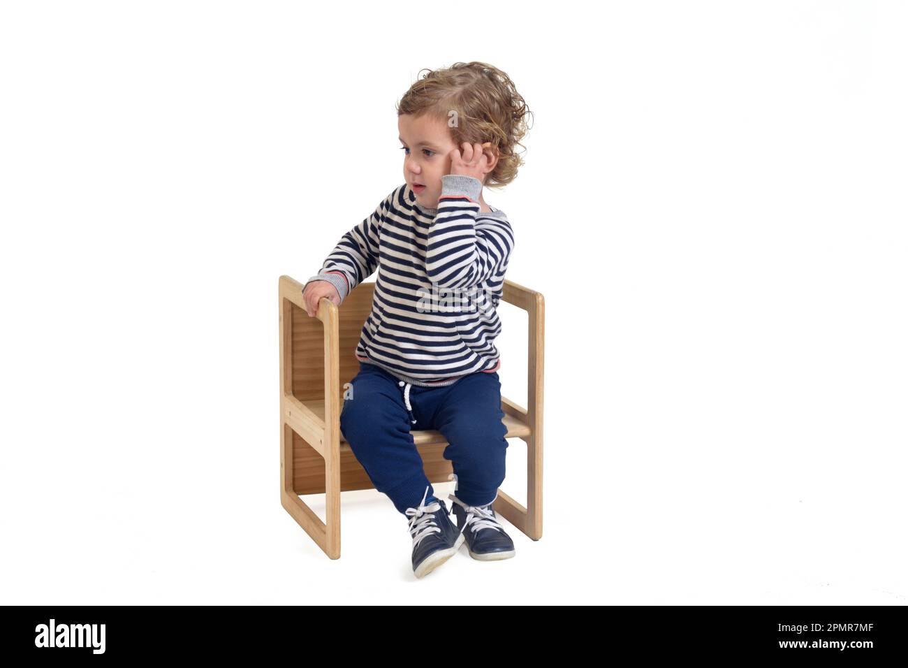 baby boy sitting on a chair with his hand on his face in thinking Stock ...