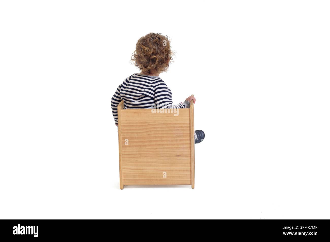 back view of a baby boy sitting on chair on white background Stock ...