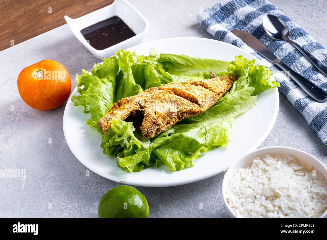 Fried "peroa" fish, lettuce salad, tomato, lemon, rice, beans and ...