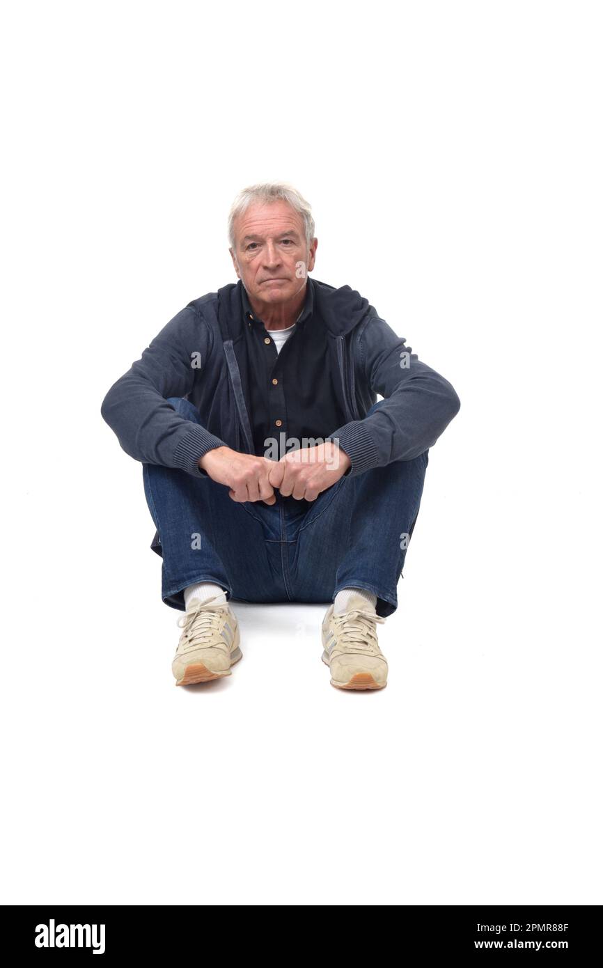 front view of a man sitting on the floor with legs folded and serious ...