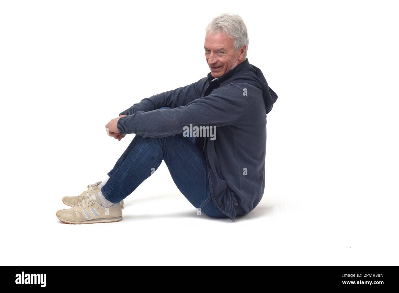 man sitting on the floor with legs folded and looking at camera on ...
