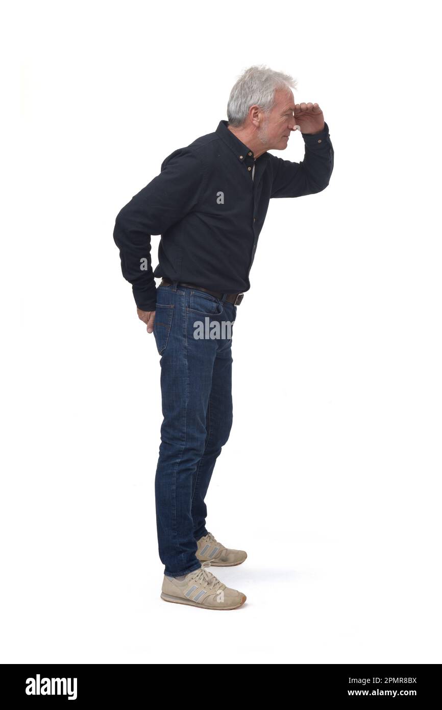 side view of standing man looking with hand on forehead on white ...