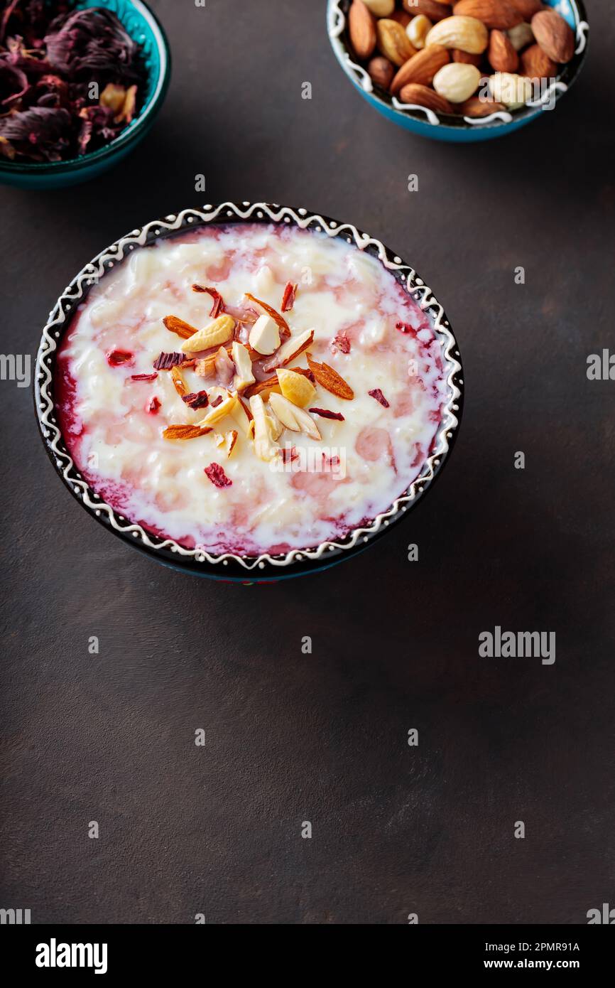 Rice pudding with sprinkled nuts on dark background. Delicious rice ...