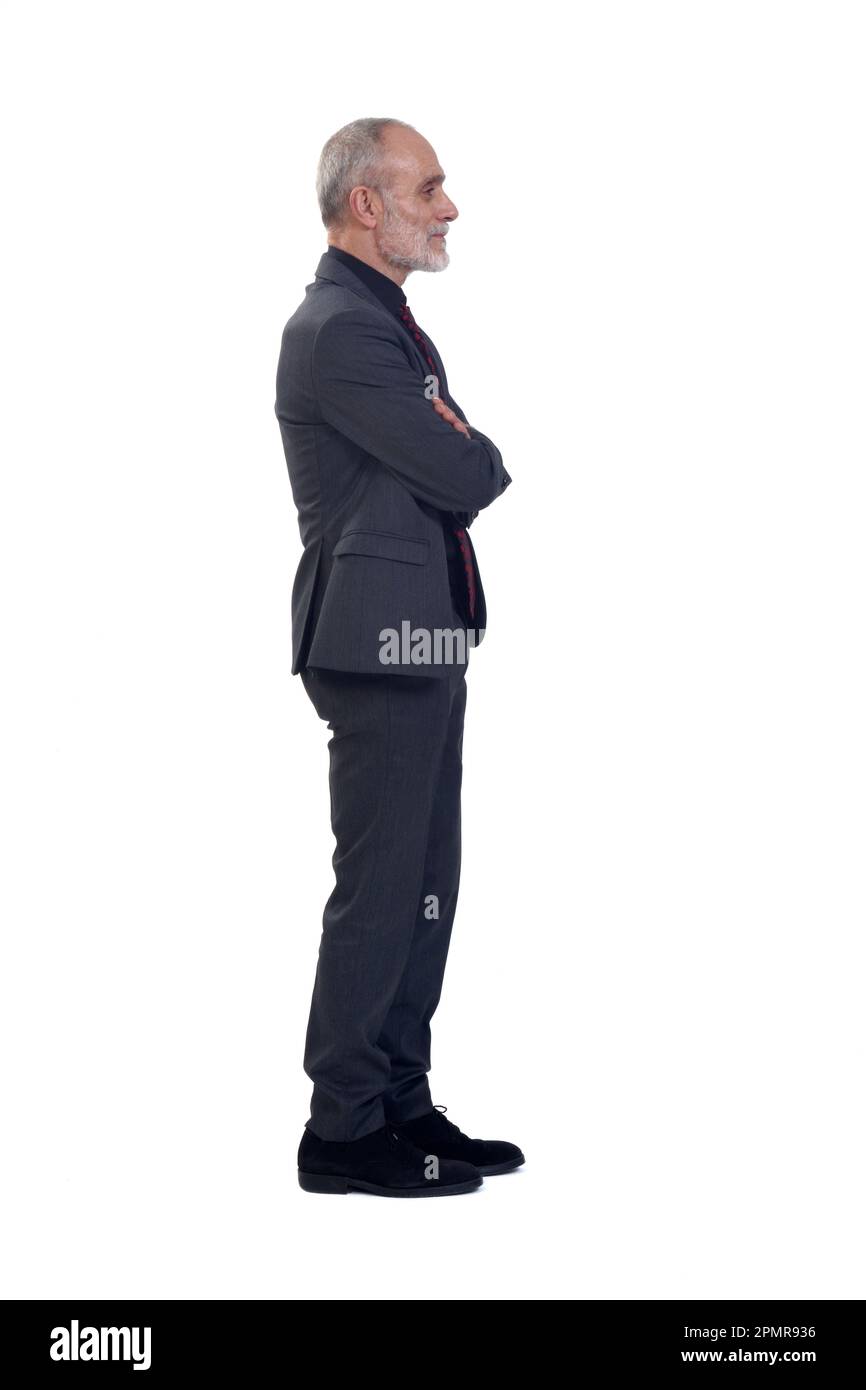 side view of a man standing with suit and arms crossed on white ...