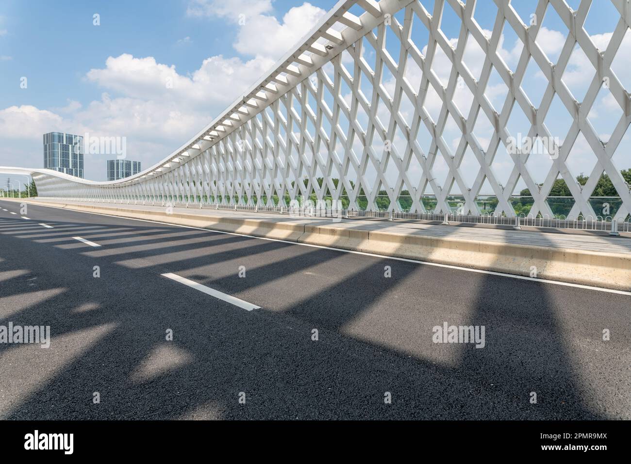 An empty asphalt road on the bridge in downtown against the cloudy sky ...