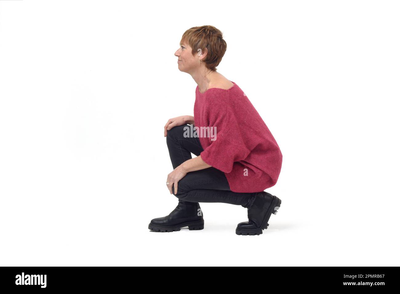 side view of a woman squatting on white background Stock Photo - Alamy
