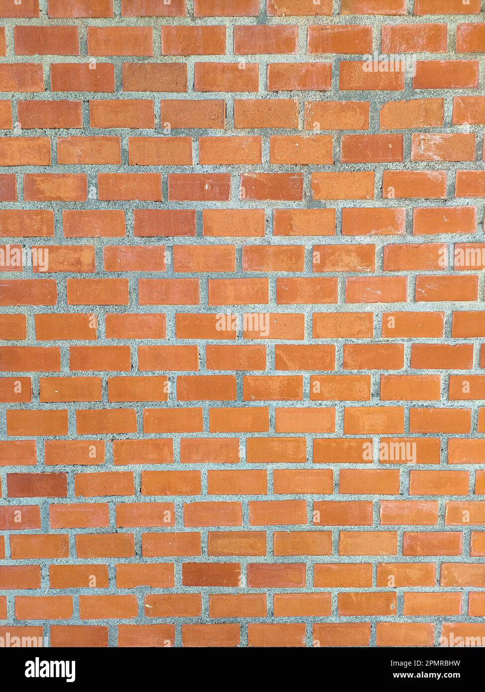 A bright orange brick wall, featuring a textured surface with various ...