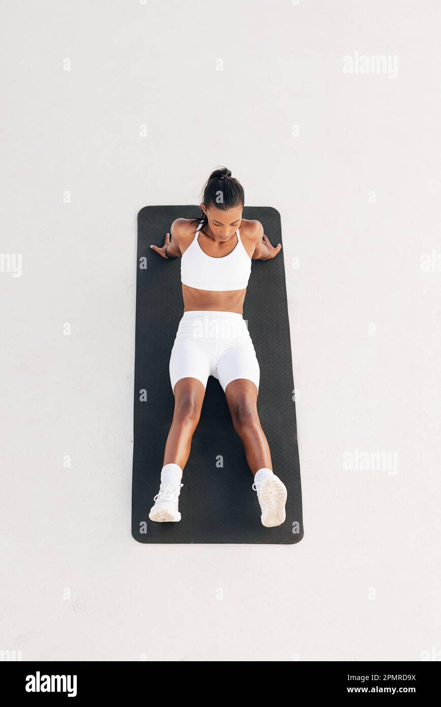 Shot from above of a young sportswoman relaxing on a mat. Female in ...