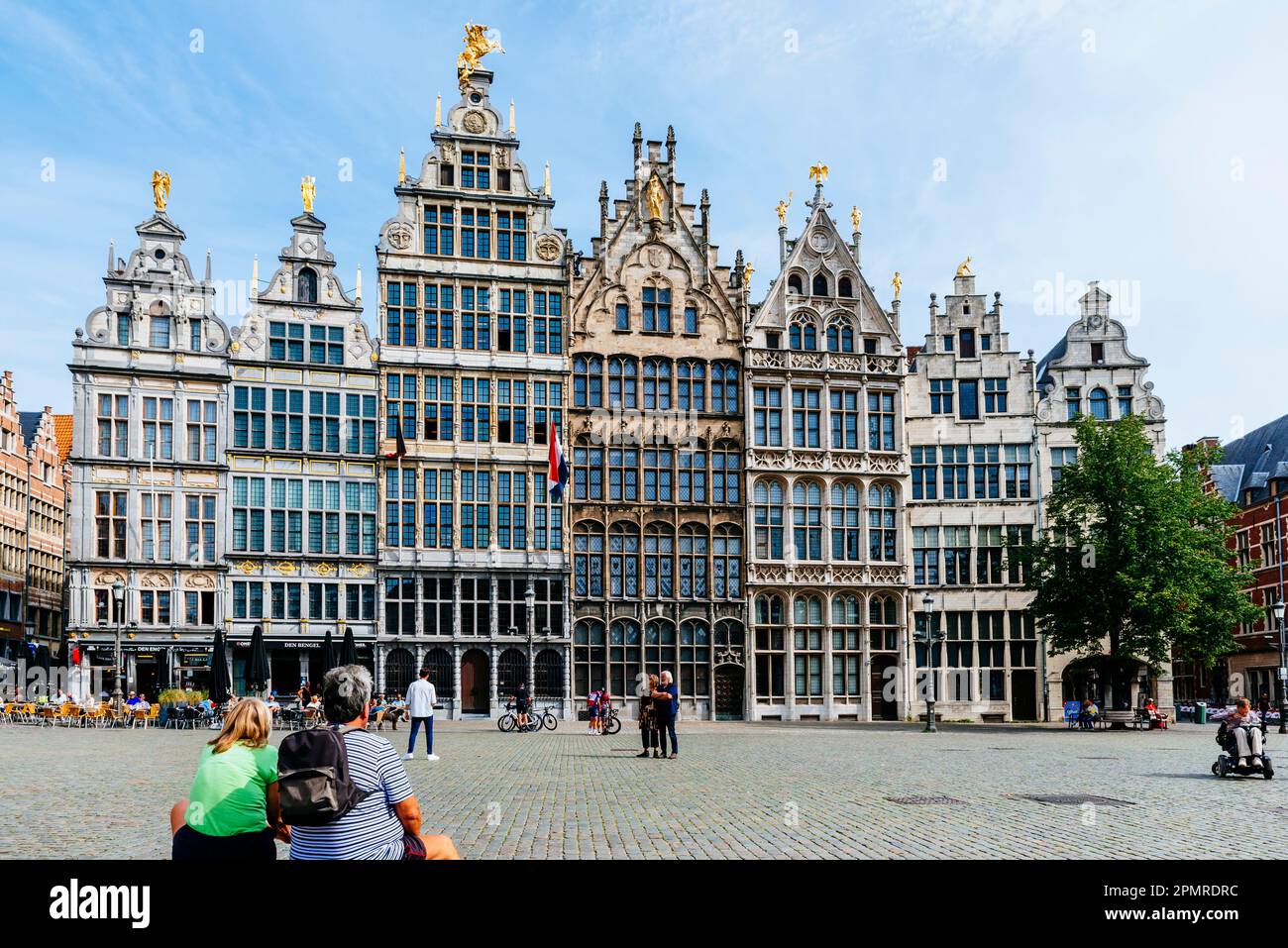 Couple sitting and looking. Guild Houses in Grote Markt, is a row of ...