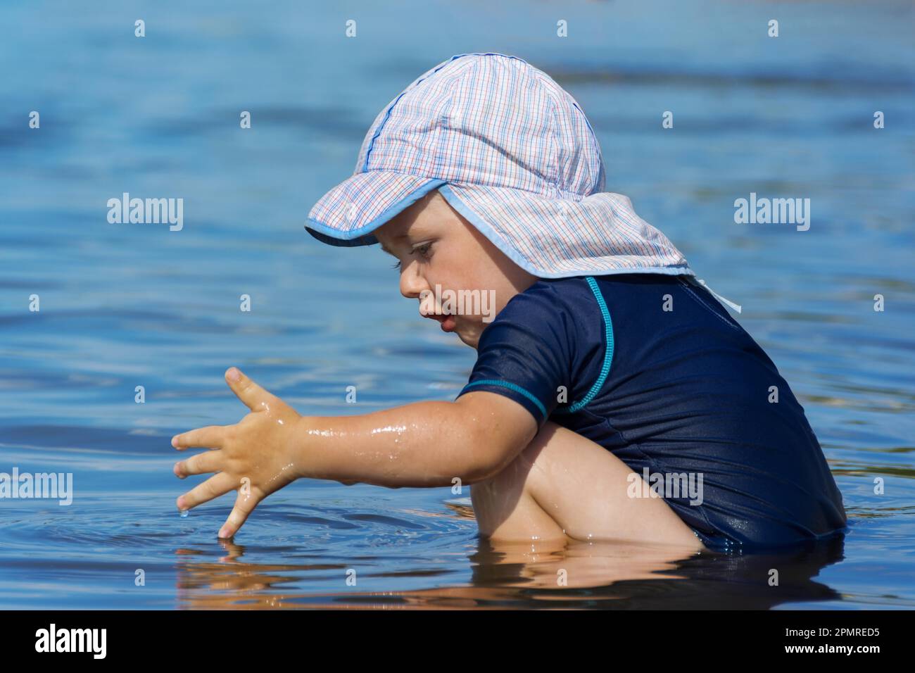 Toddler plays alone in the water Stock Photo - Alamy