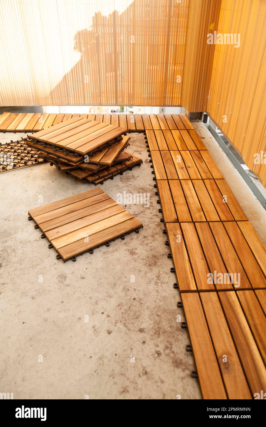 Laying of wooden patio tiles on balcony, Germany Stock Photo - Alamy