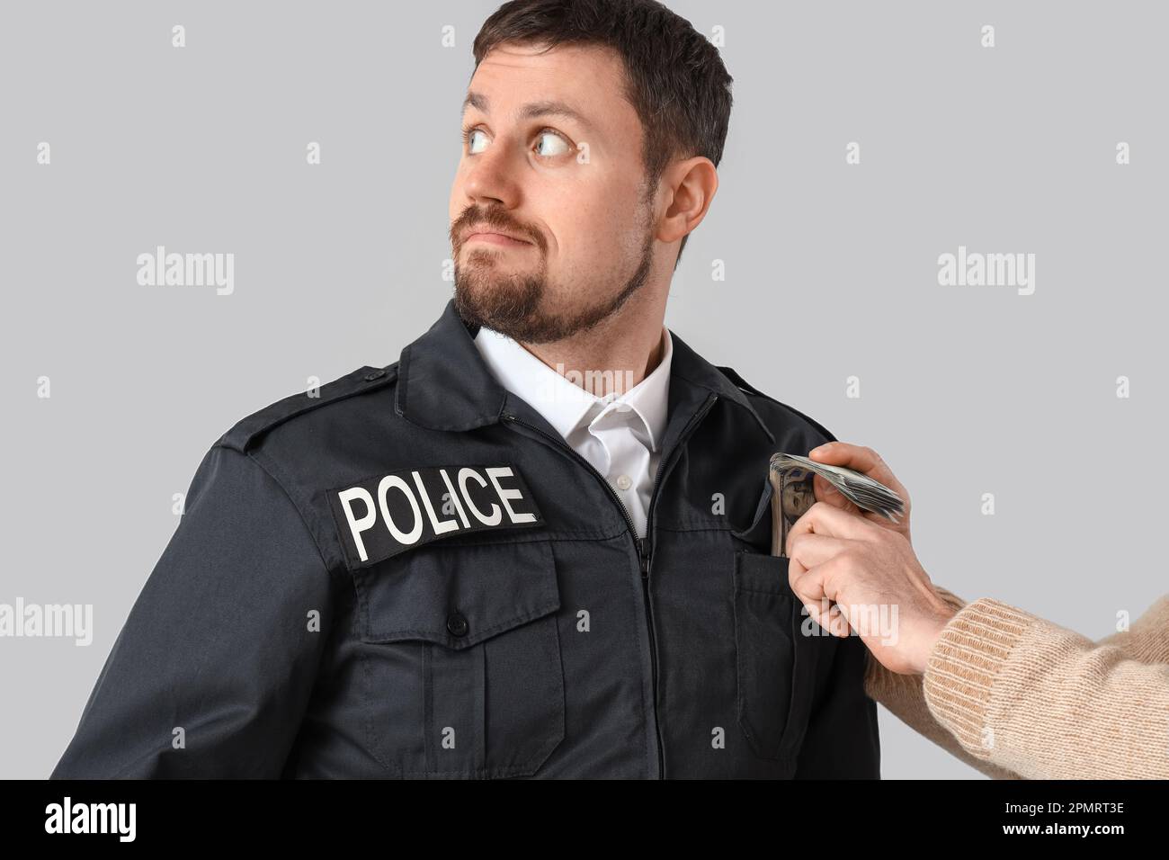 Mature man giving bribe to policeman on grey background Stock Photo - Alamy
