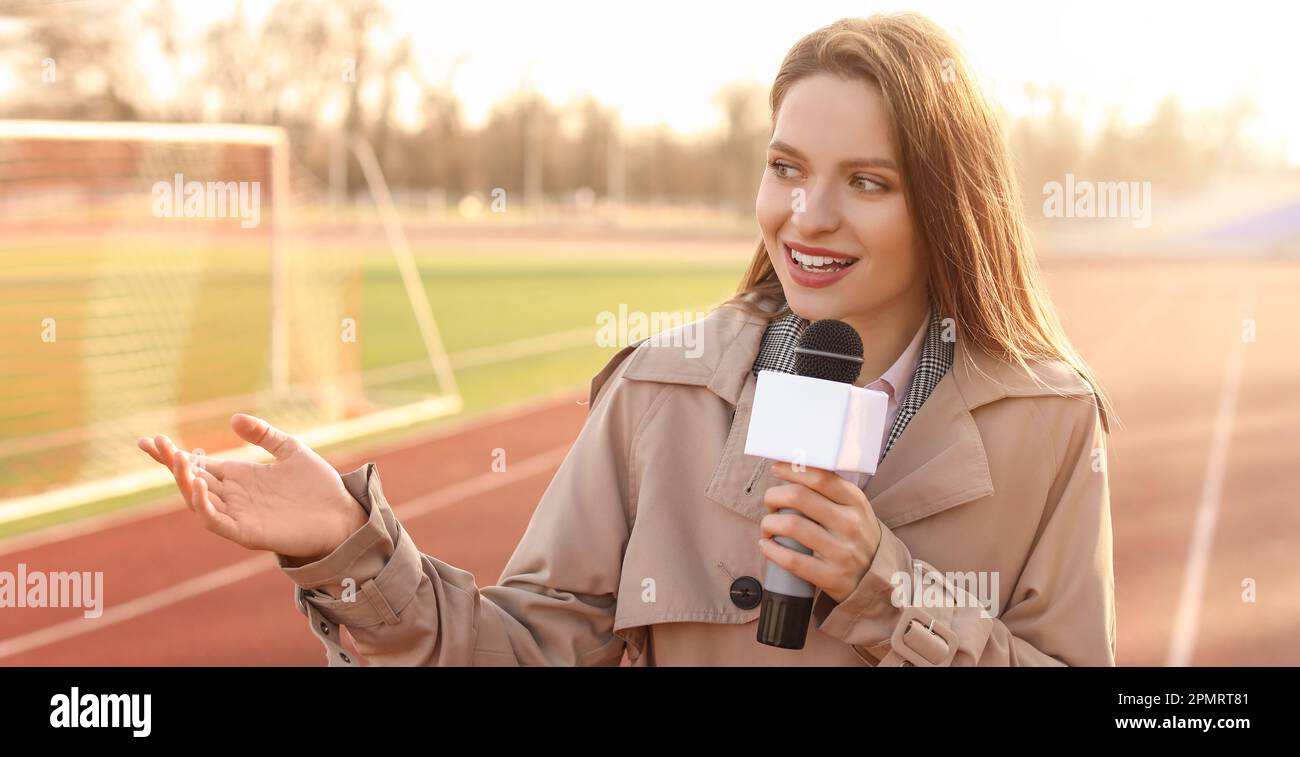 Beautiful reporter with microphone at the stadium Stock Photo - Alamy