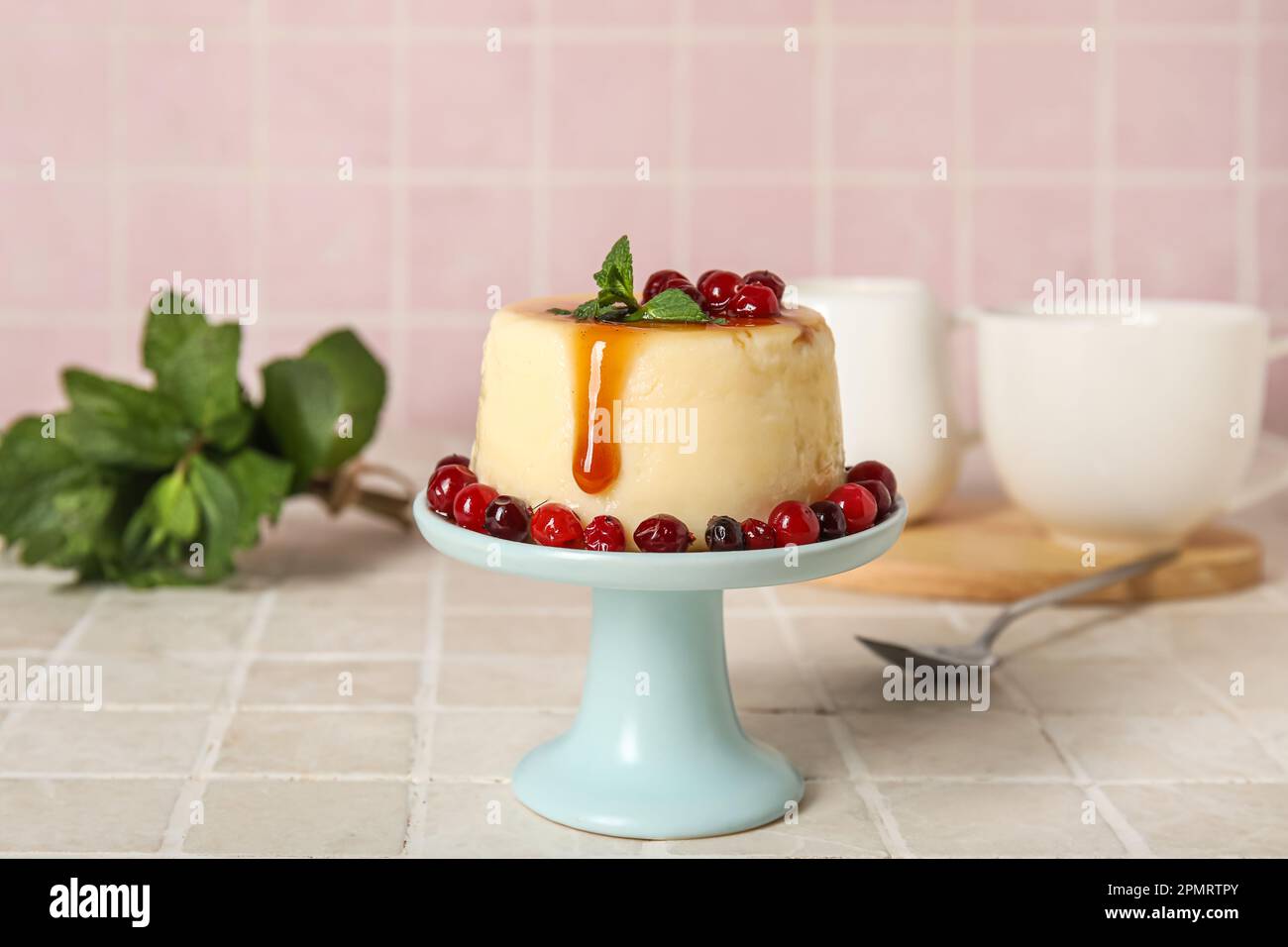 Dessert stand with delicious pudding, mint and cranberries covered by ...