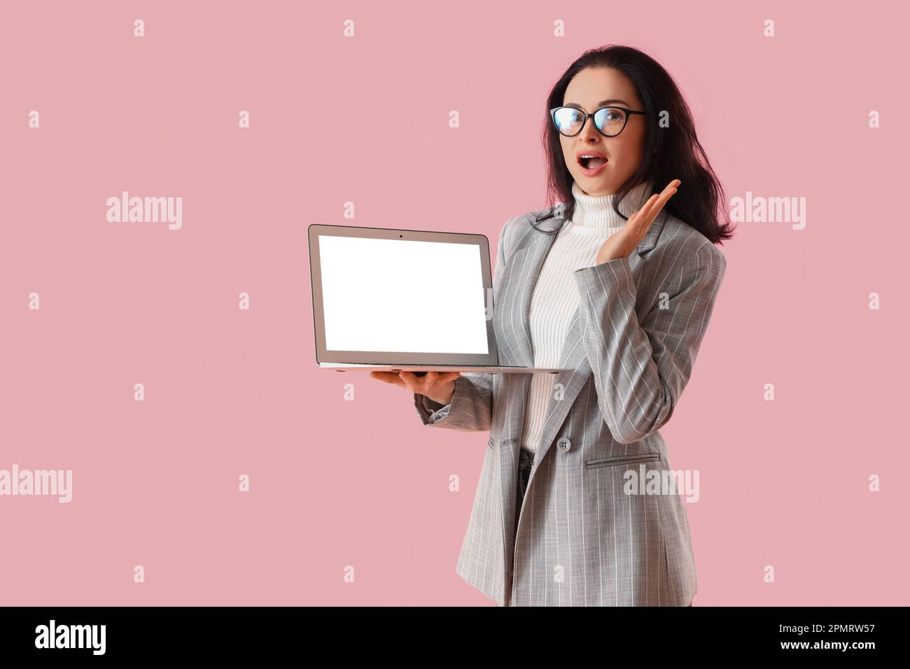 Female teacher of computer sciences with laptop on pink background ...
