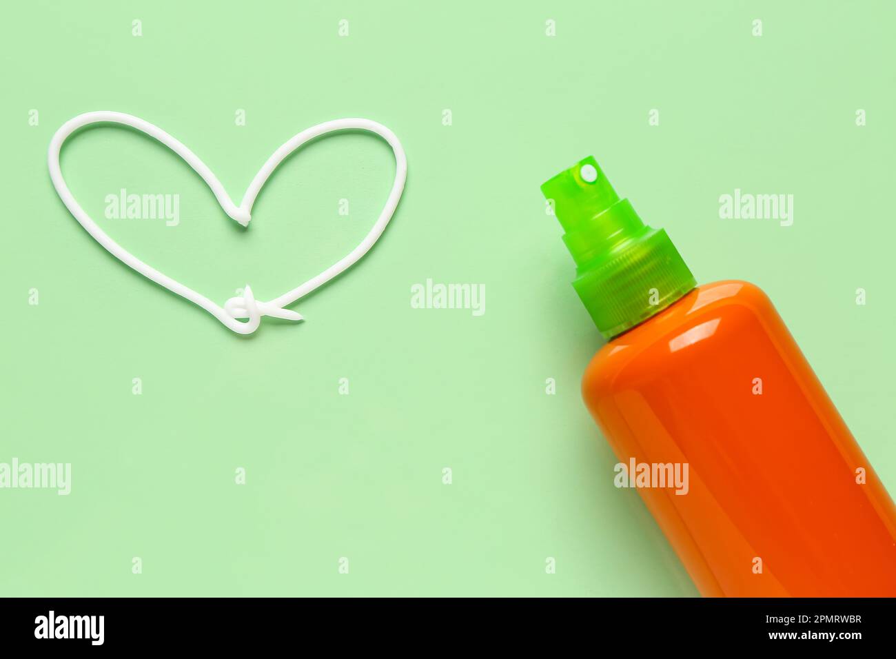 Sunscreen and heart made of cream on green background Stock Photo - Alamy