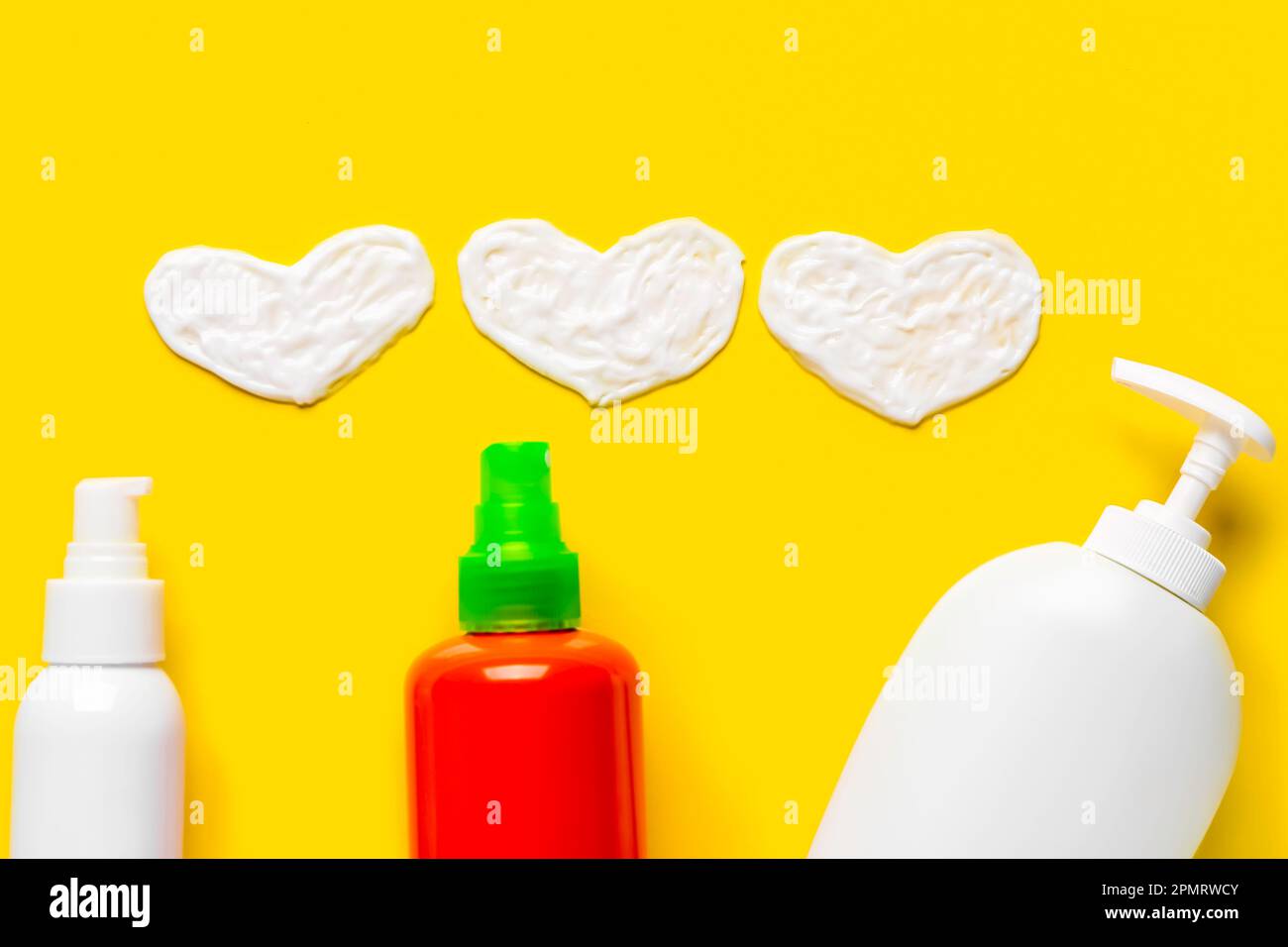 Hearts made of sunscreen cream on yellow background Stock Photo - Alamy