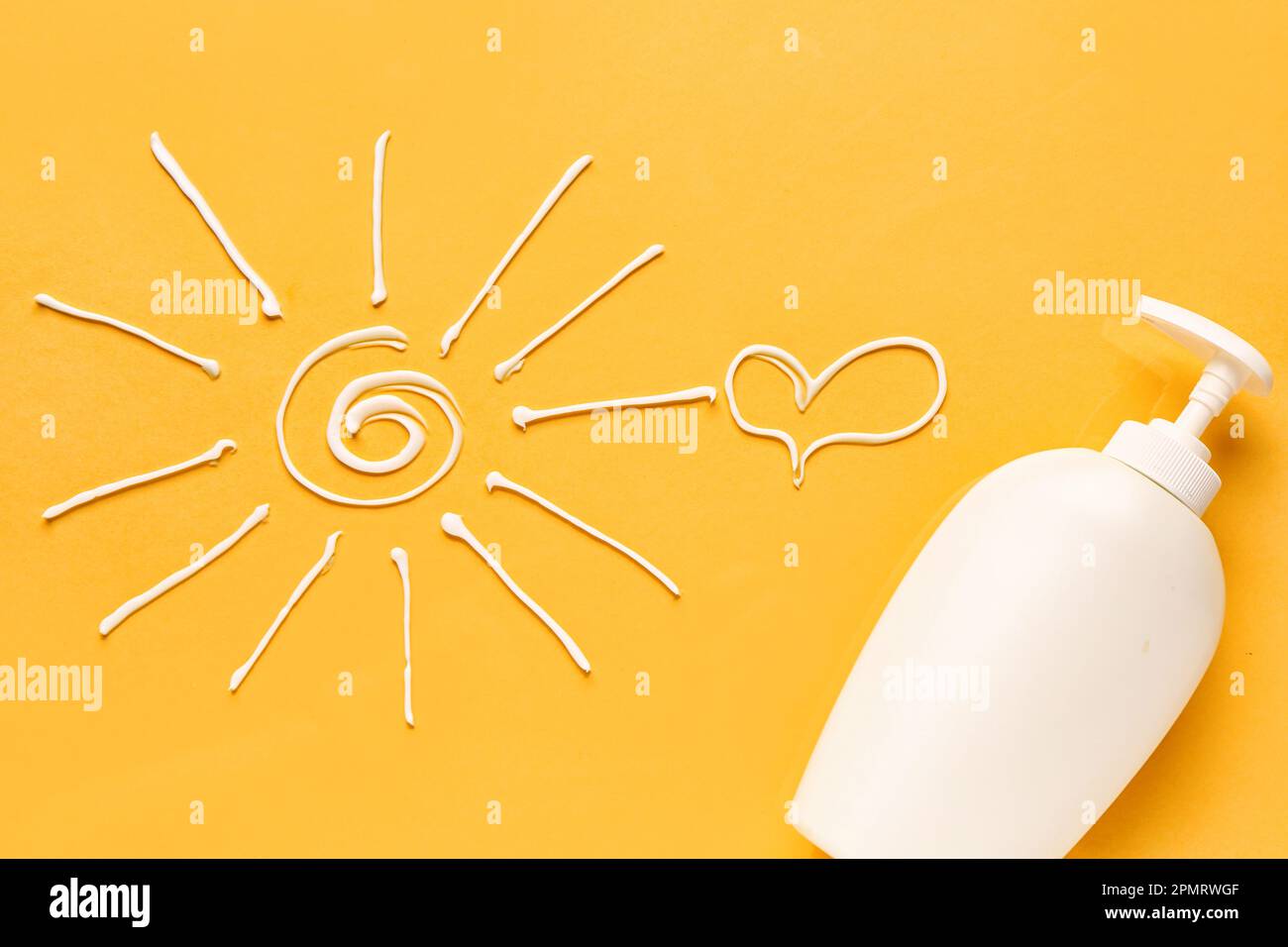Drawings of sun and heart made with sunscreen cream on yellow ...