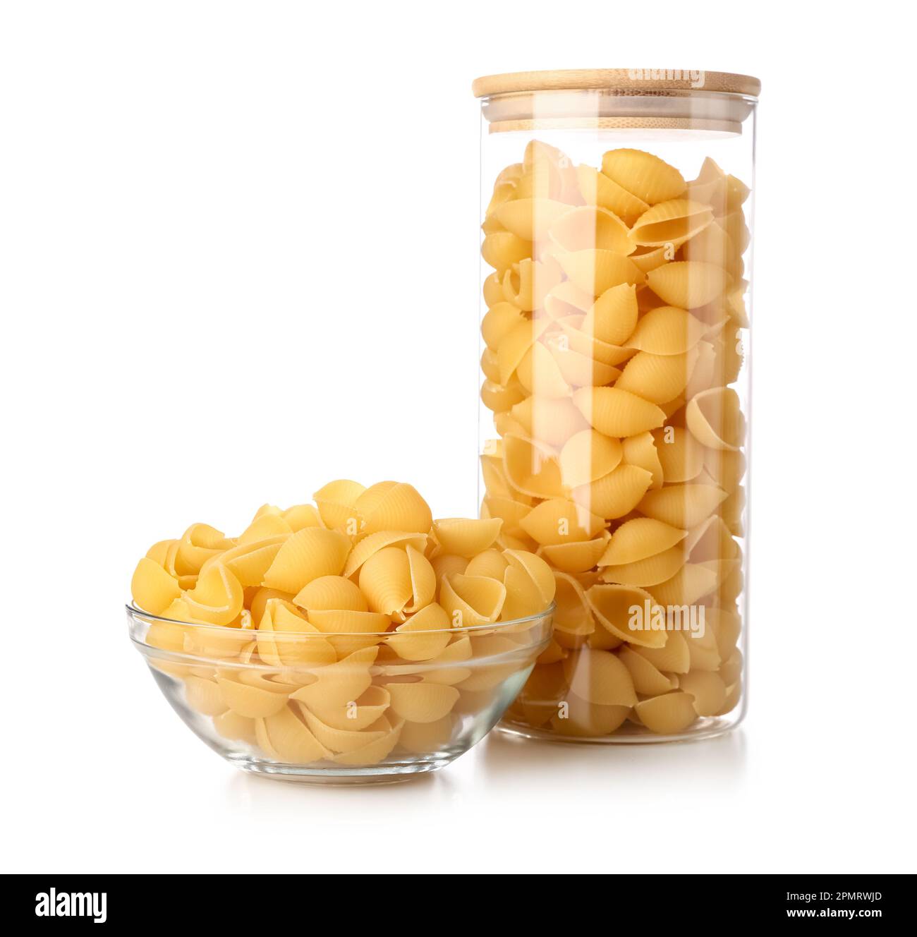 Jar and bowl of raw conchiglie pasta isolated on white background Stock ...