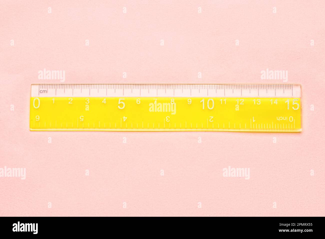 Yellow plastic ruler on pink background Stock Photo - Alamy