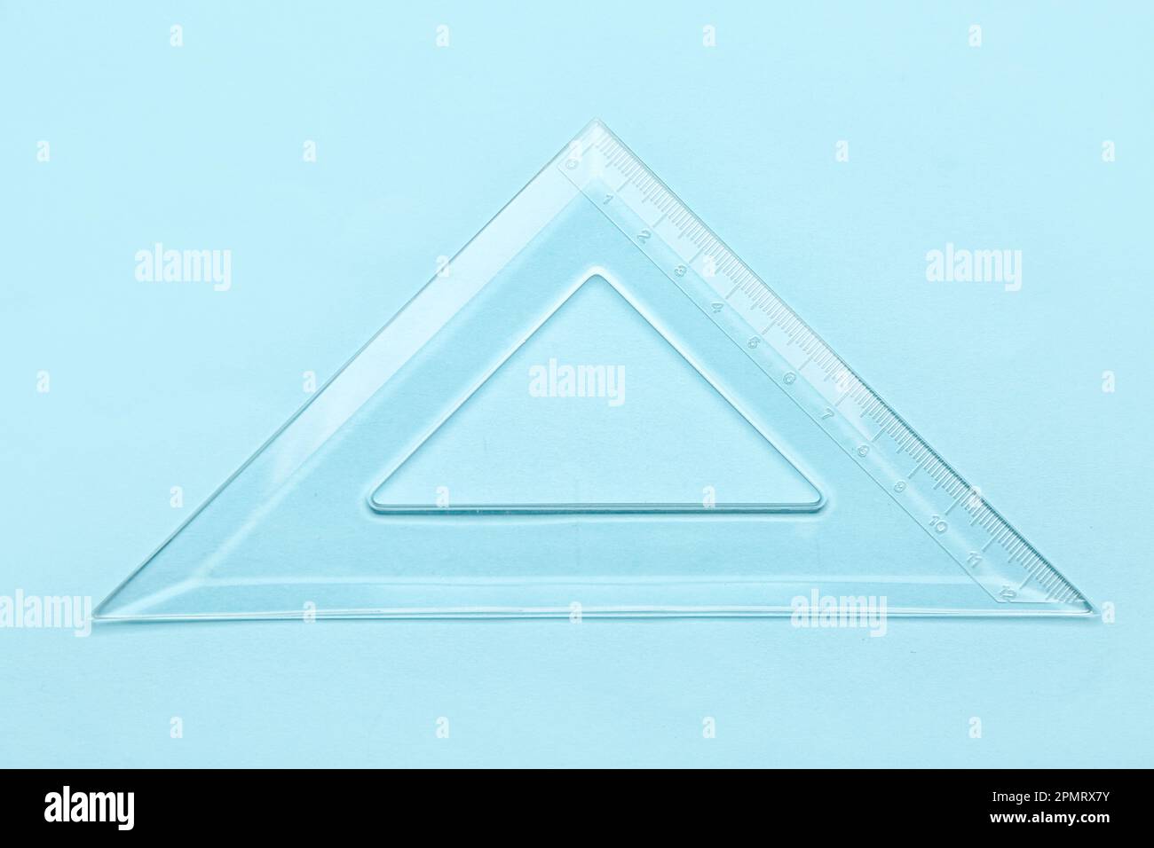 Transparent triangle plastic ruler on blue background Stock Photo - Alamy