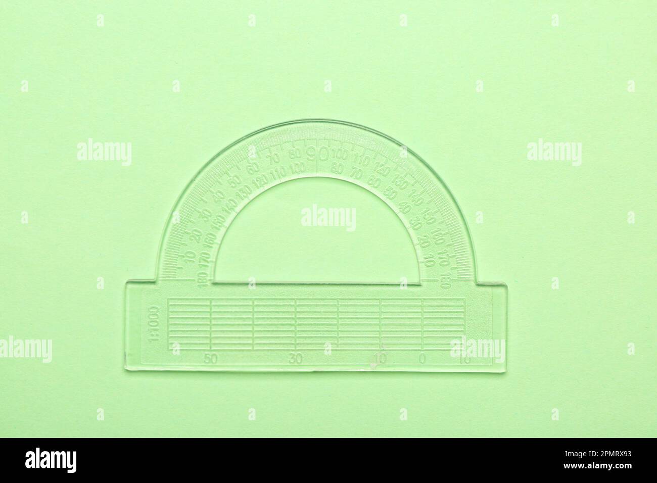 Transparent plastic protractor on green background Stock Photo - Alamy