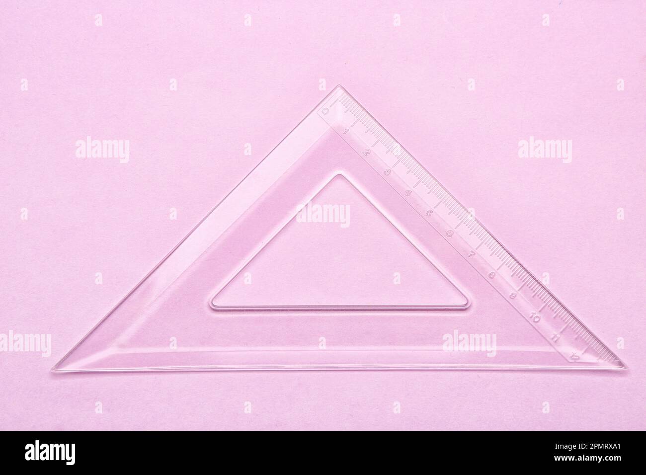 Transparent triangle plastic ruler on pink background Stock Photo - Alamy