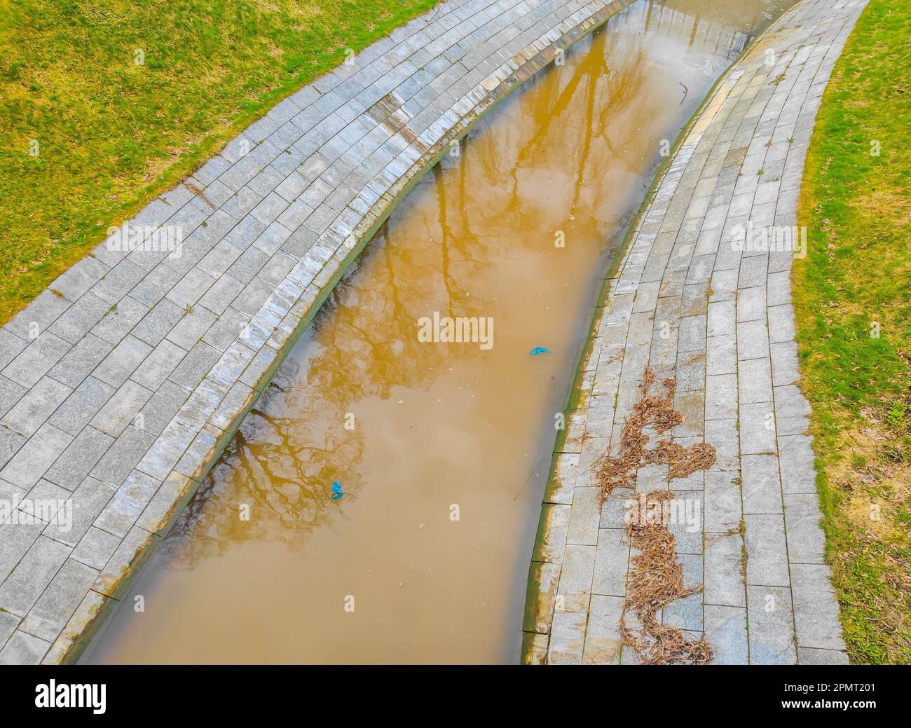 Environmental pollution of small river in city. Water pollution. Brown ...