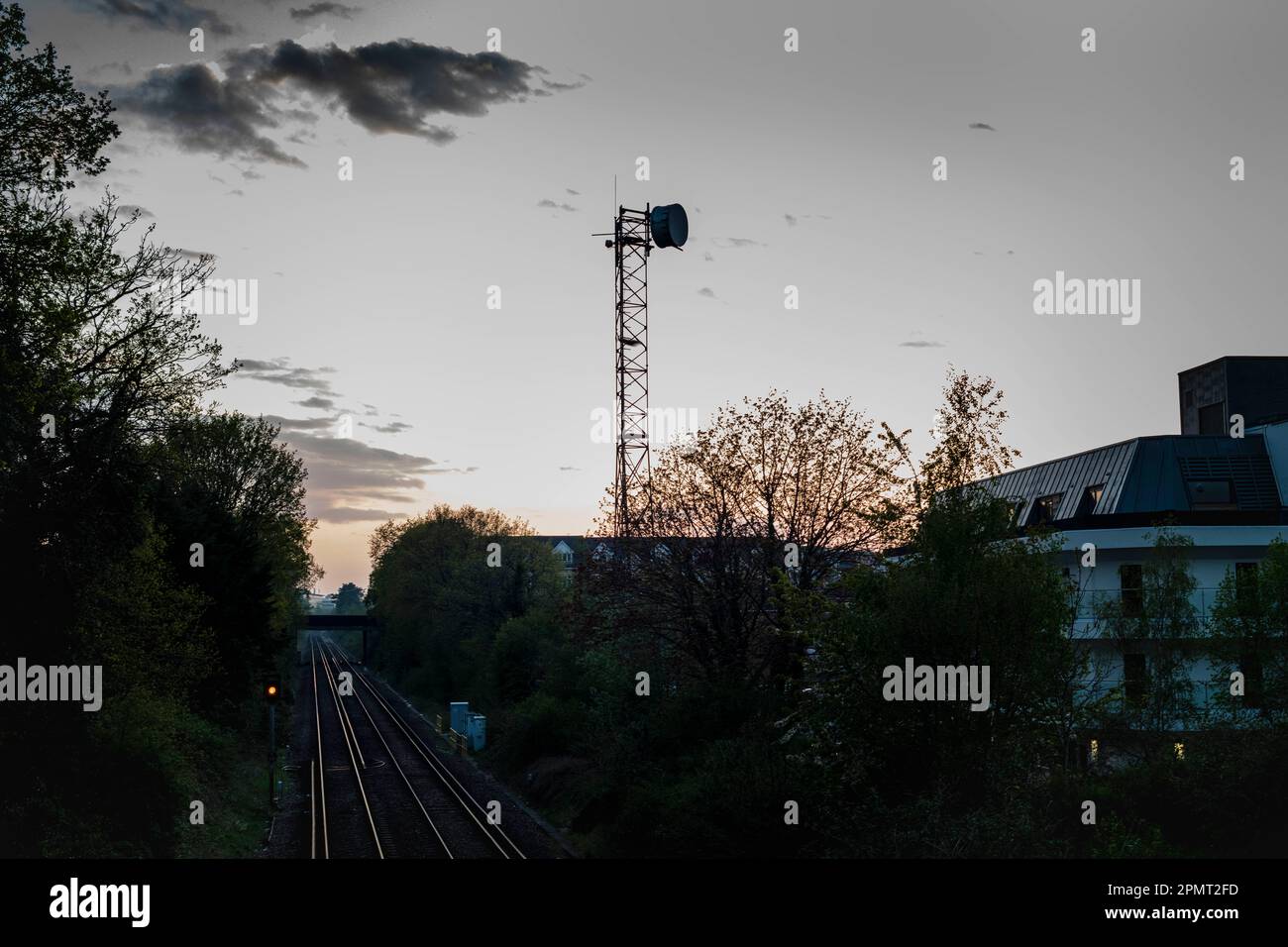 Train line at sunset Communication tower apartments/ flats at sunset ...