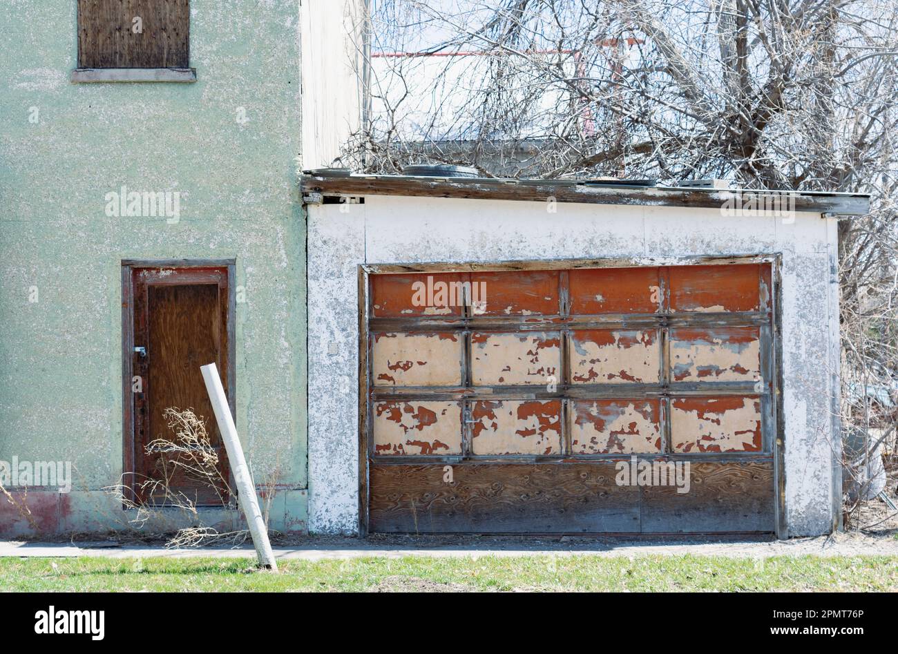 Abandoned building & garage in small town America are closed. Door is ...