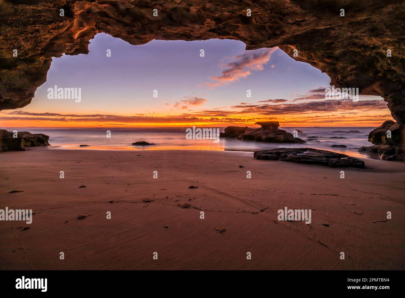 Spectacular colourful sunrise at Caves beach from sandstone coastal ...