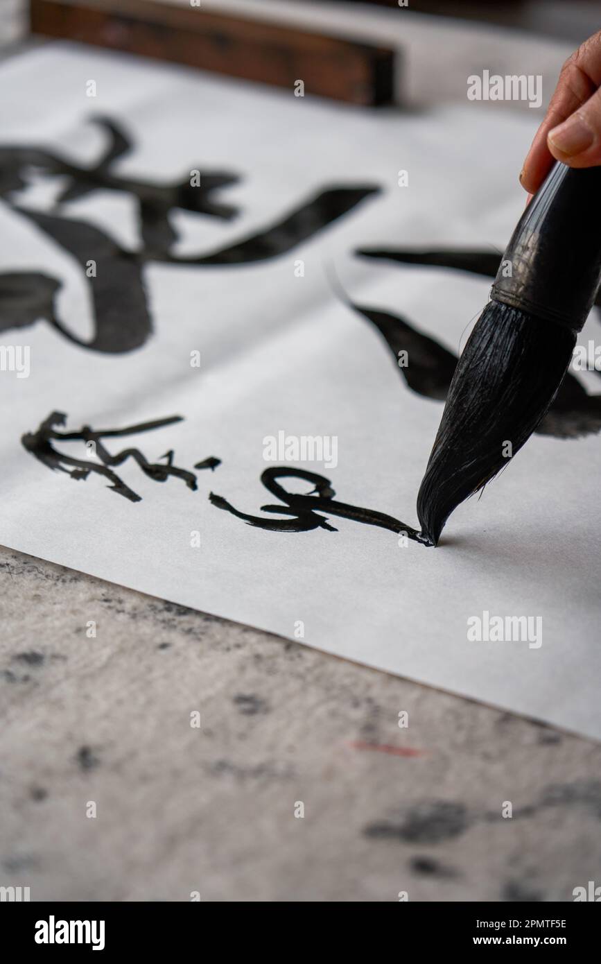 An old Chinese calligrapher is creating and writing calligraphy works ...