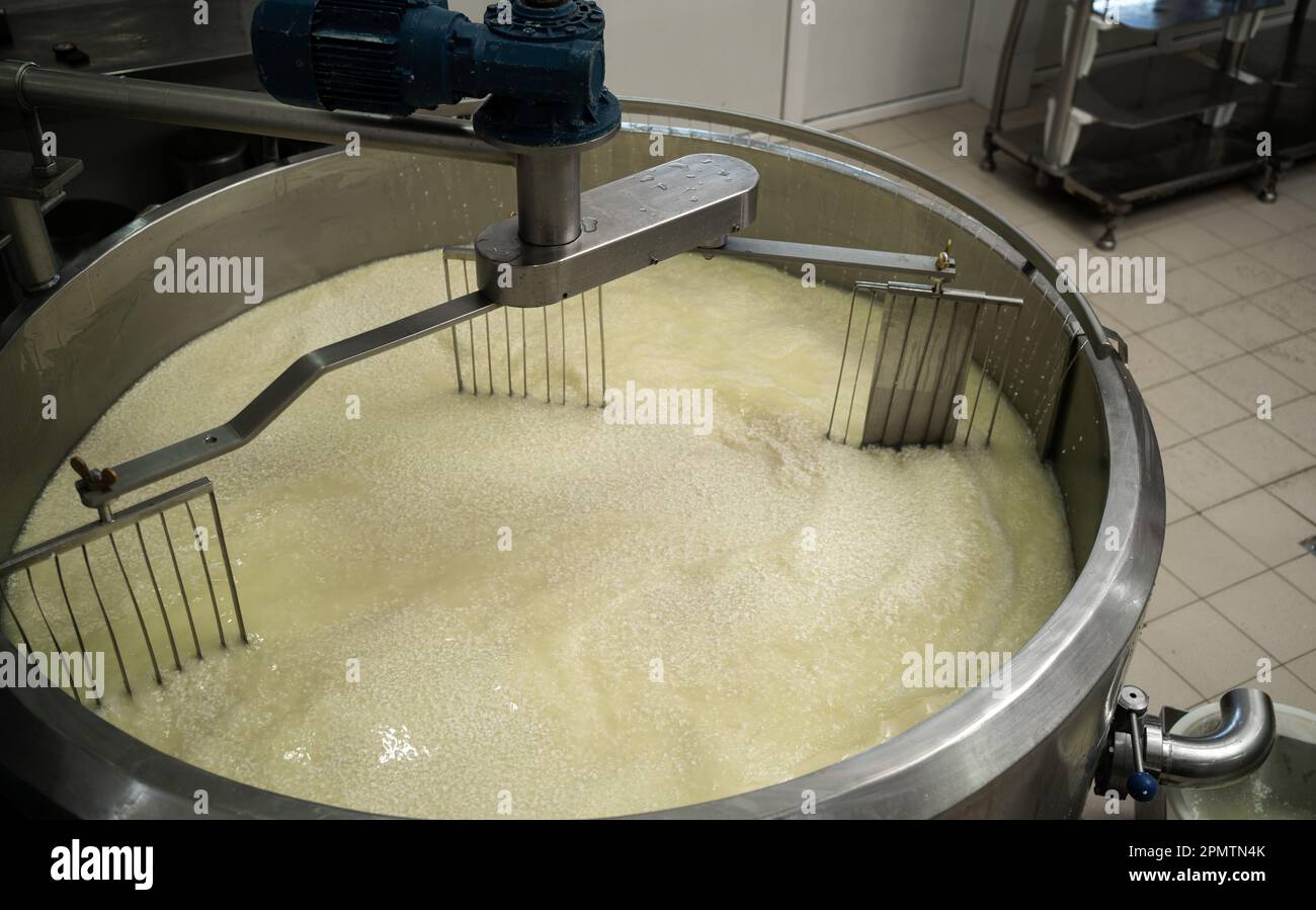 Mixing curd and whey in tank at cheese factory, top view. Copy space ...